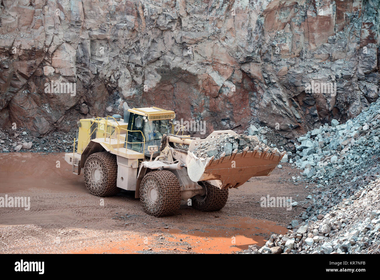 Earthmover in an active quarry mine of porphyry rocks. digging Stock ...
