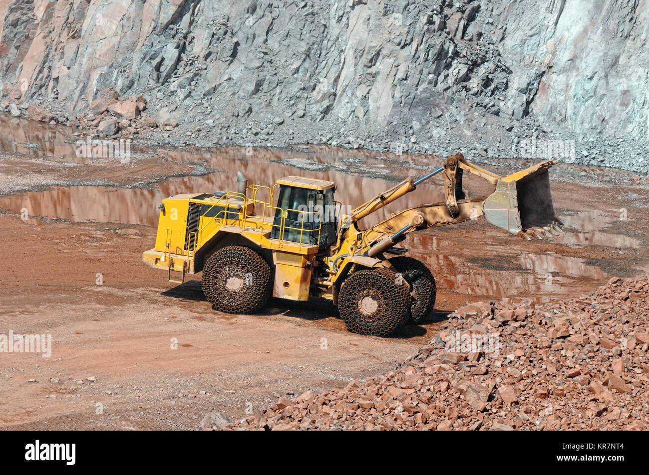 Earthmover in an active quarry mine of porphyry rocks. digging Stock ...