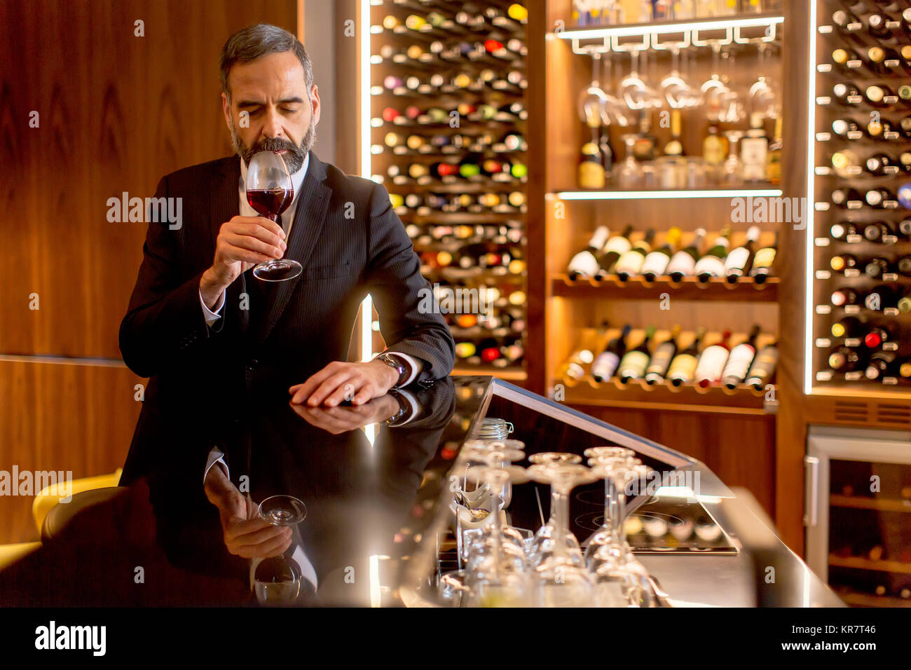 Handsome mature man tasting glass of red wine Stock Photo - Alamy