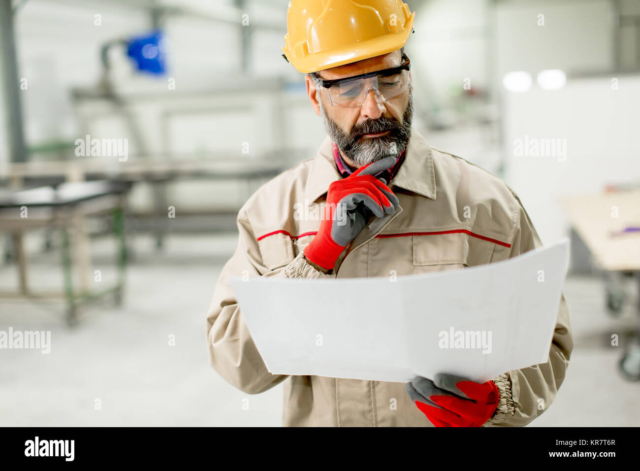 Handsome mature engineer looking at plan in the factory Stock Photo - Alamy