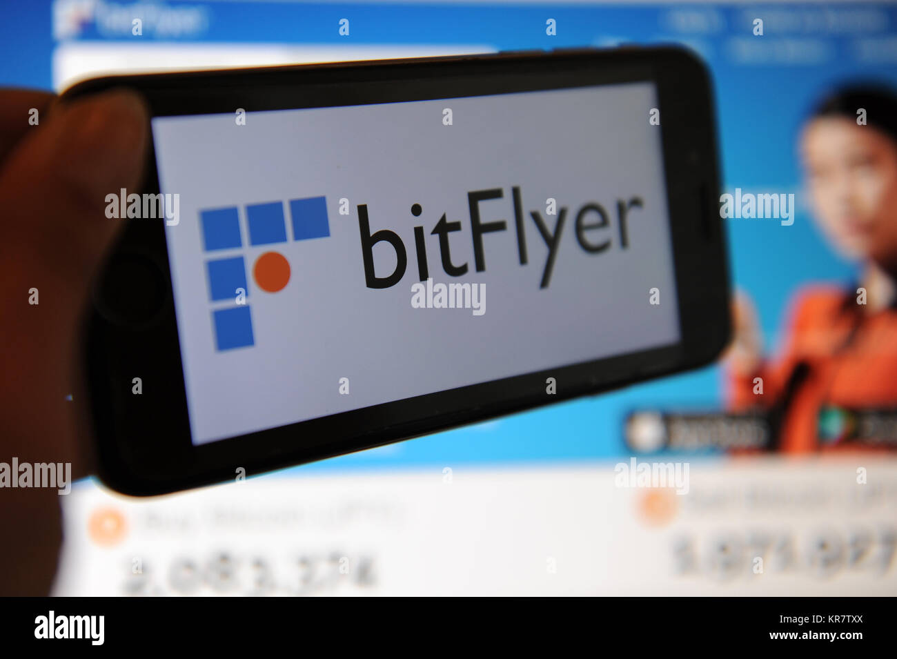 bitFlyer logo on a phone and the bitFlyer website on a computer screen ...
