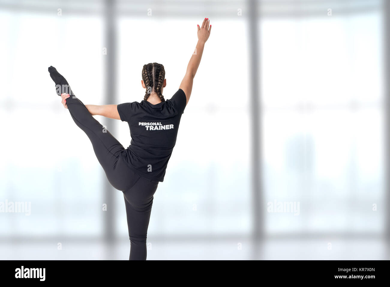 Personal Trainer standing with one leg up in a gym Stock Photo - Alamy