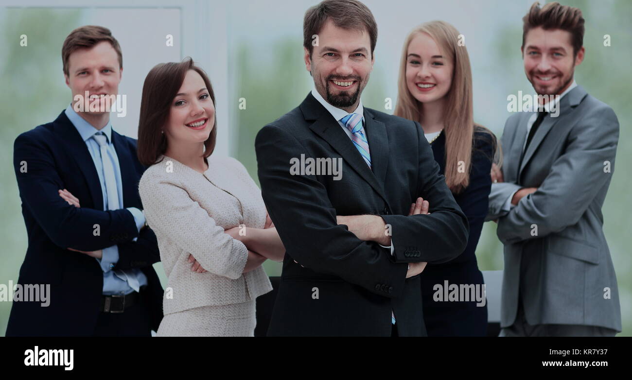 Smiling business team standing upright with their hands on their Stock ...