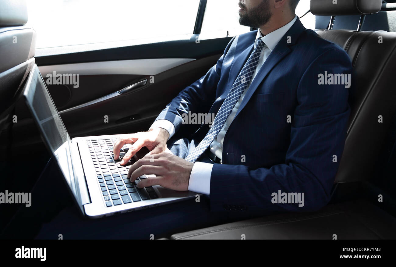 Businessman working with laptop sitting in car Stock Photo - Alamy
