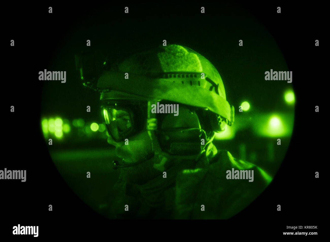 A U.S. military member looks forward while riding in the back of a ...