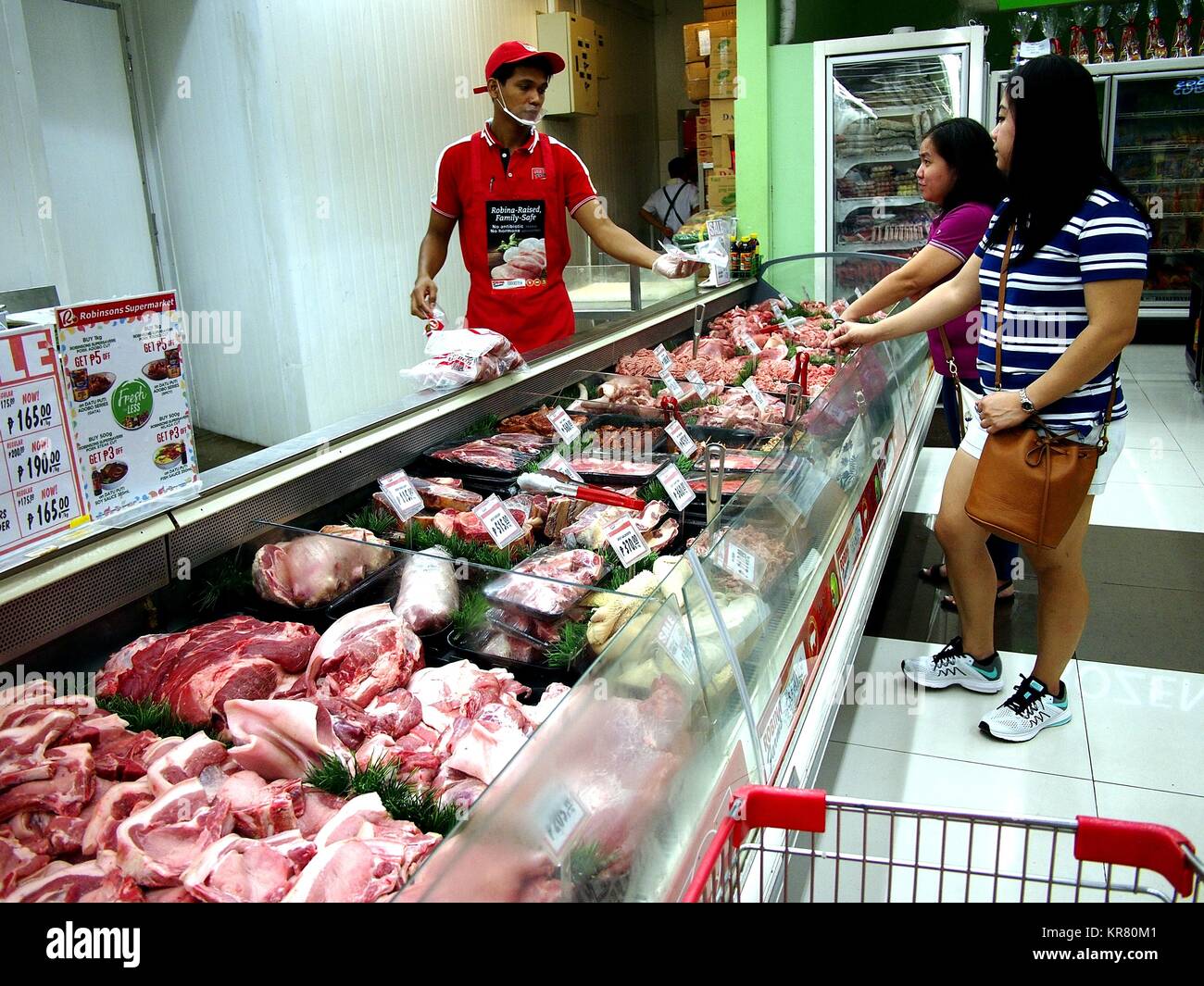 ANTIPOLO, PHILIPPINES - DECEMBER 11, 2017: A butcher at a meat section ...