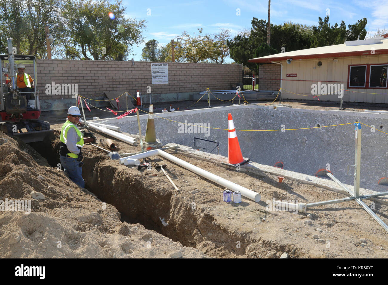 Workers from Larco Construction dig a trench for a new pool drain at the Oasis Pool and Splash ...