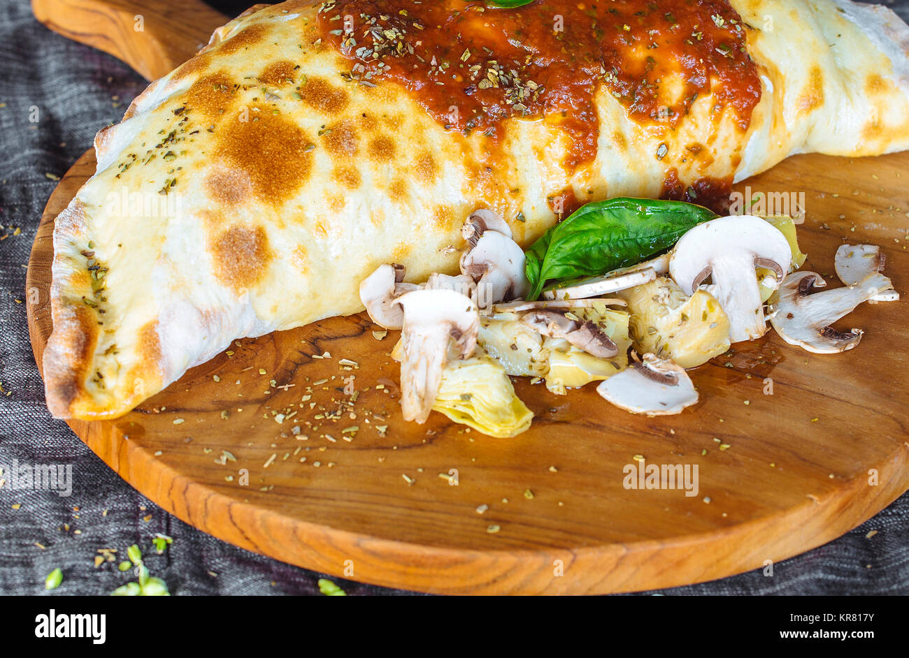 Calzone pizza, filled herbs, cheese and tomatoes Stock Photo - Alamy