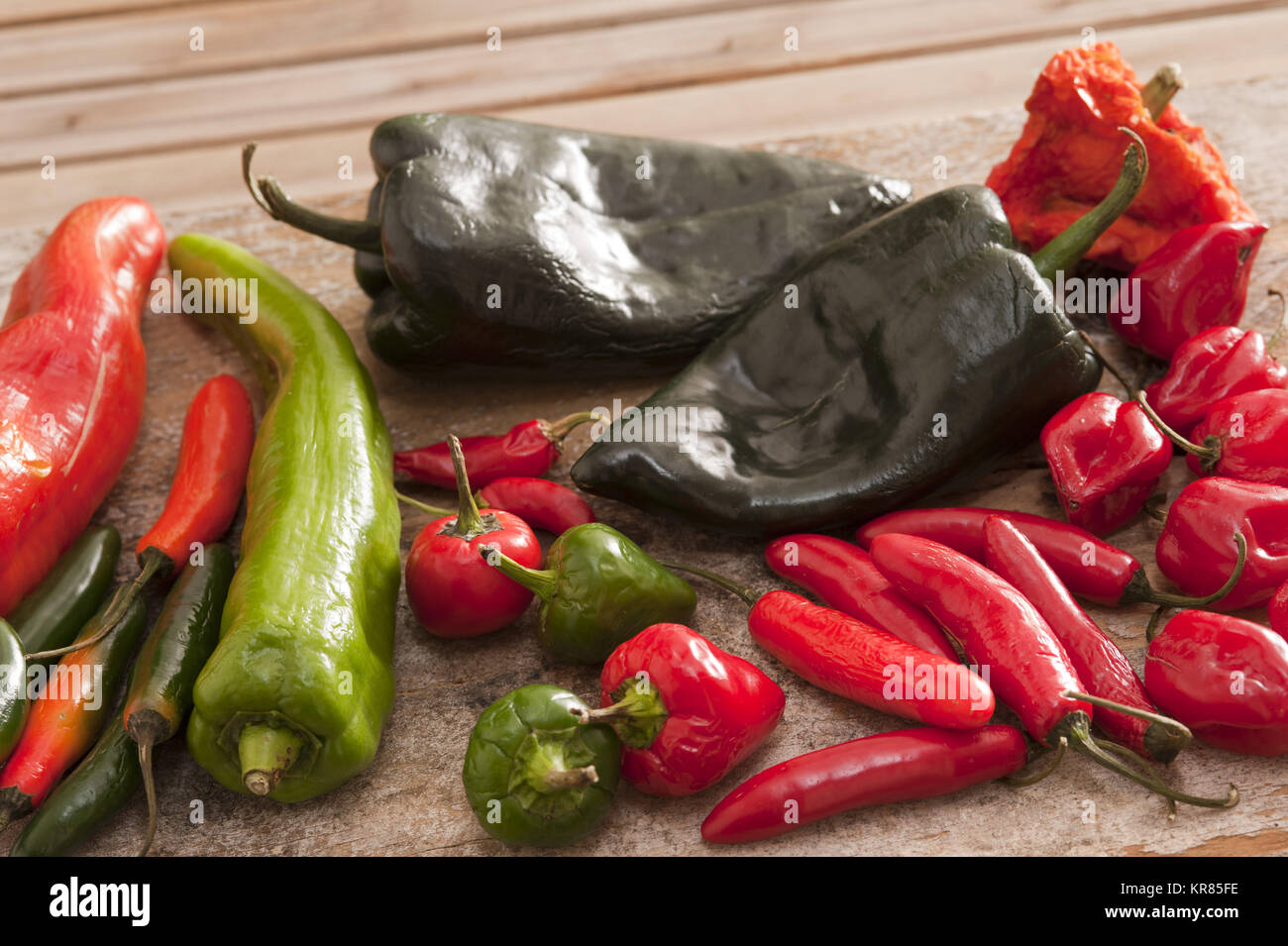 Various hot peppers scattered on cutting board Stock Photo - Alamy