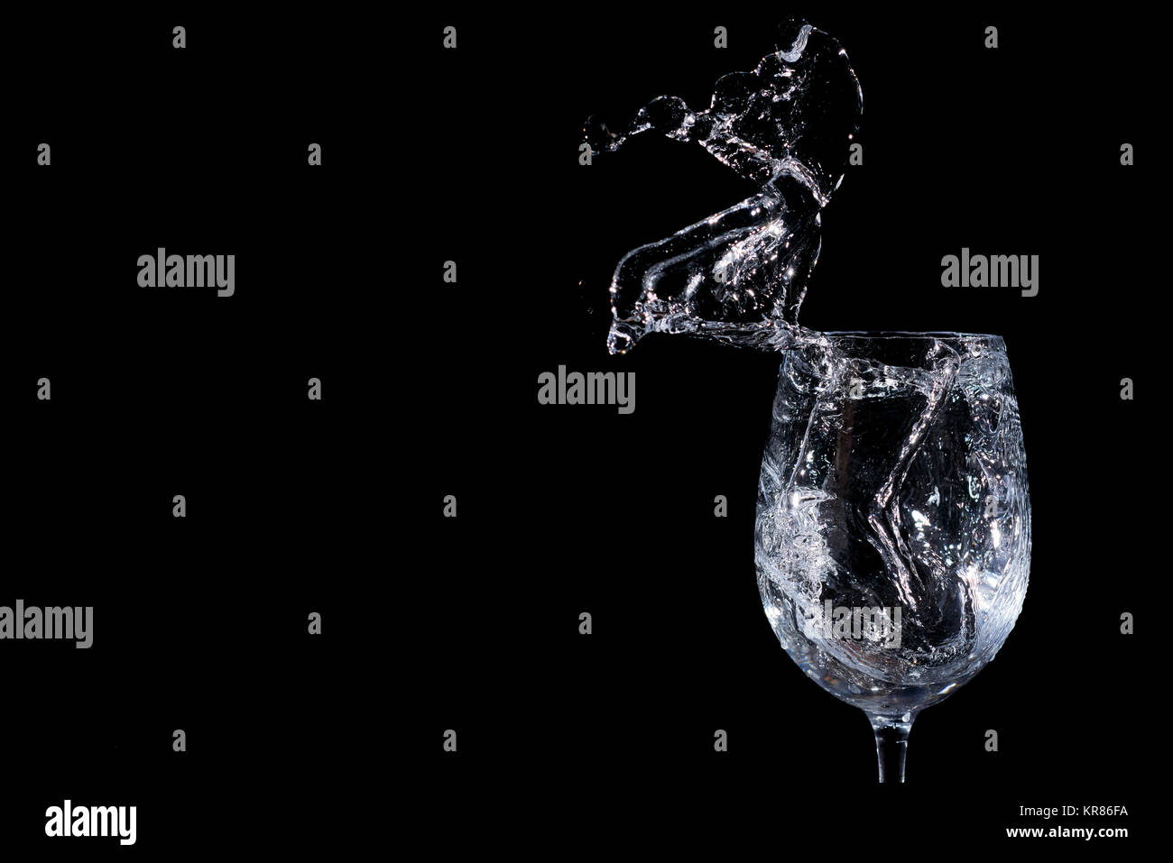 Water splash in a glass on a black background Stock Photo - Alamy
