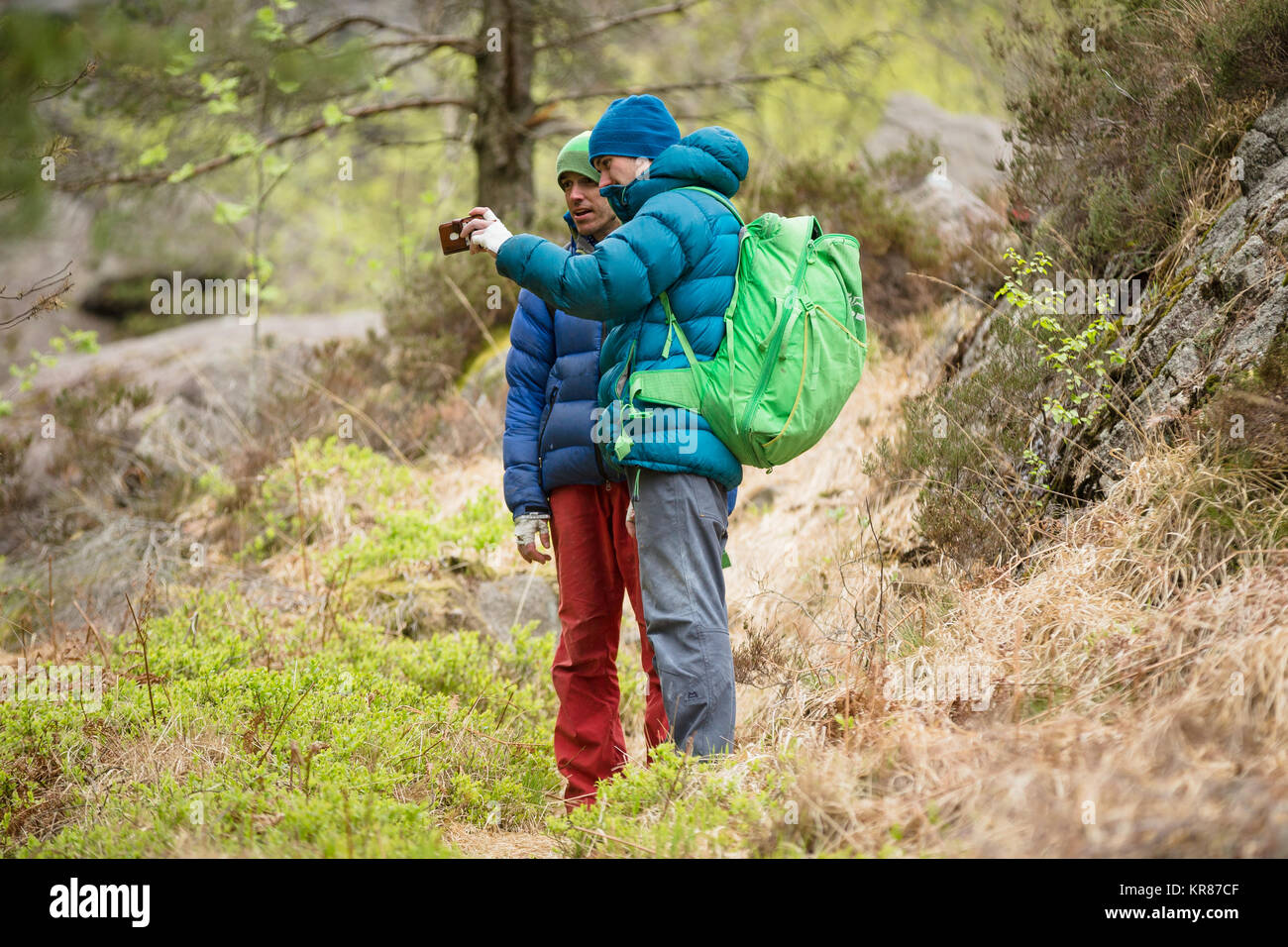 Rock climbers walk through a wood to a climbing route Stock Photo - Alamy