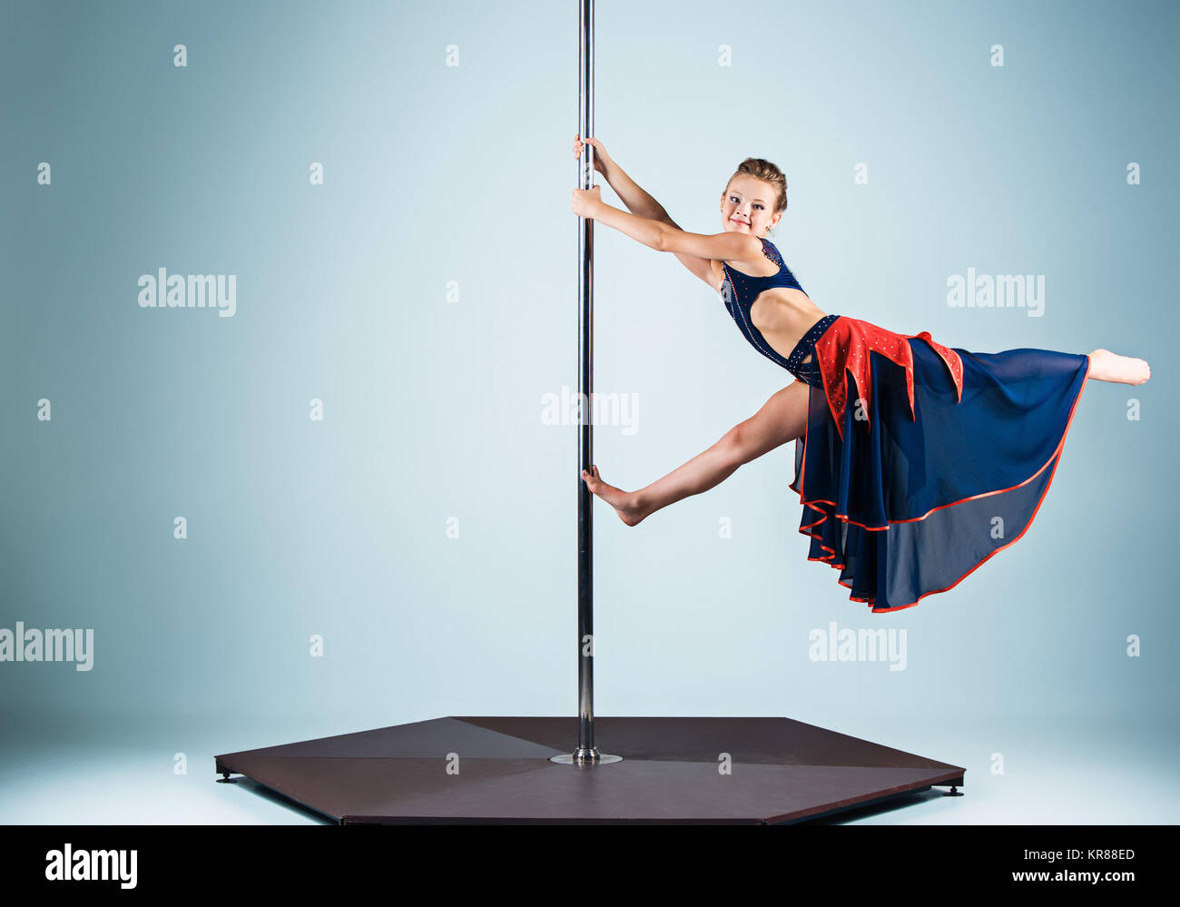 The strong and graceful young girl performing acrobatic exercises on ...