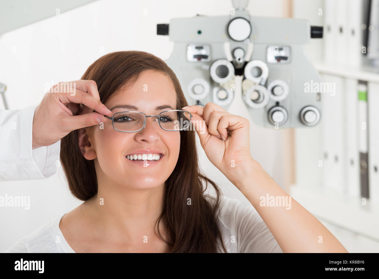 Male Optician Holding Eyeglasses On Woman's Face Stock Photo - Alamy