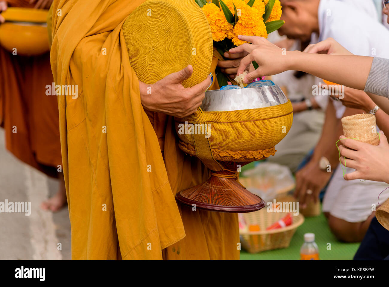 Give food alms to a buddhist monk Stock Photo - Alamy