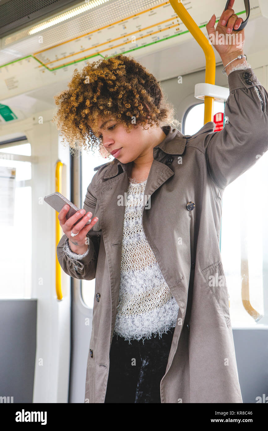 Texting on the train Stock Photo - Alamy