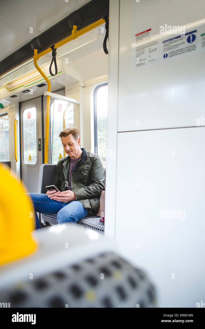 Texting on the Train Stock Photo - Alamy