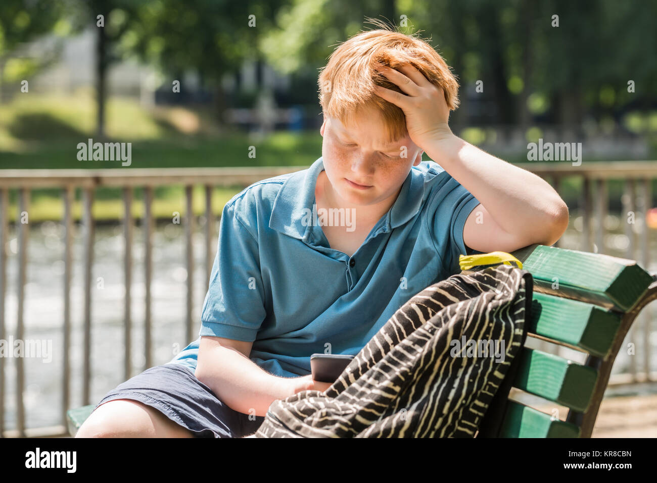 Schoolboy Looking At Cellphone Stock Photo - Alamy