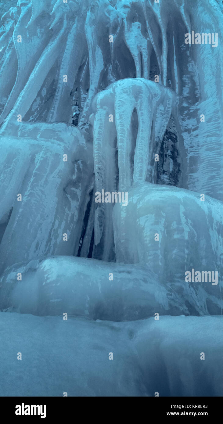 Frozen waterfall stream. Vertical slippery steep ice wall with long ...