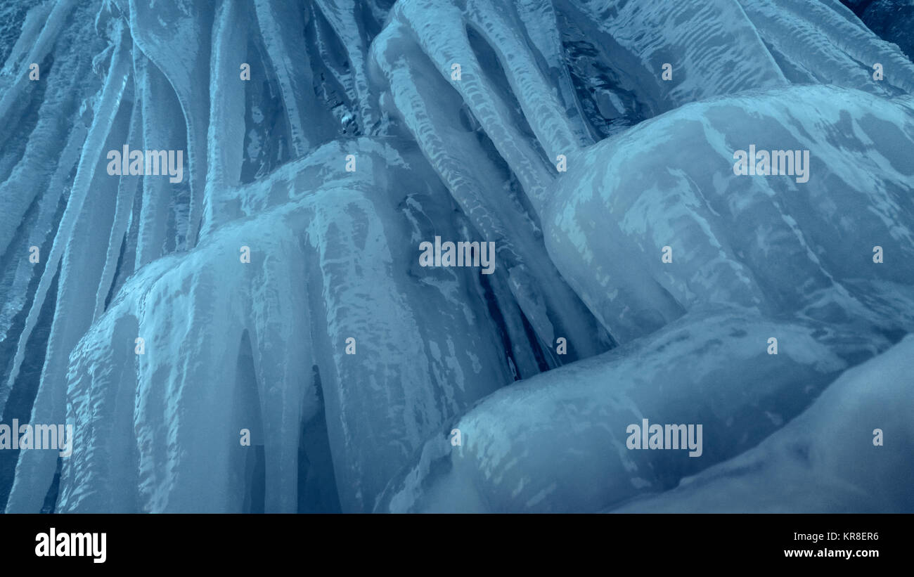 Frozen waterfall stream. Vertical slippery steep ice wall with long ...