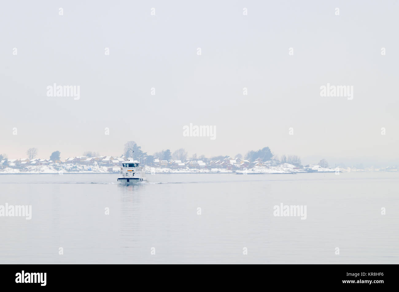 Small ferry Oslo VIII an route to Hovedoya island through winter foggy ...