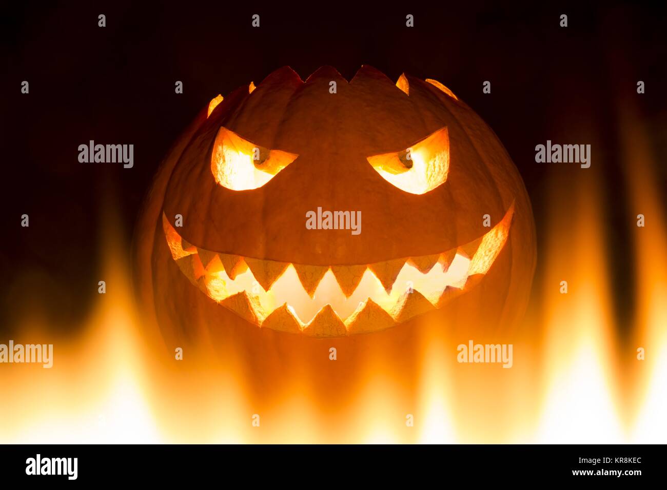 creepy carved pumpkin halloween burning with flames of fire Stock Photo ...