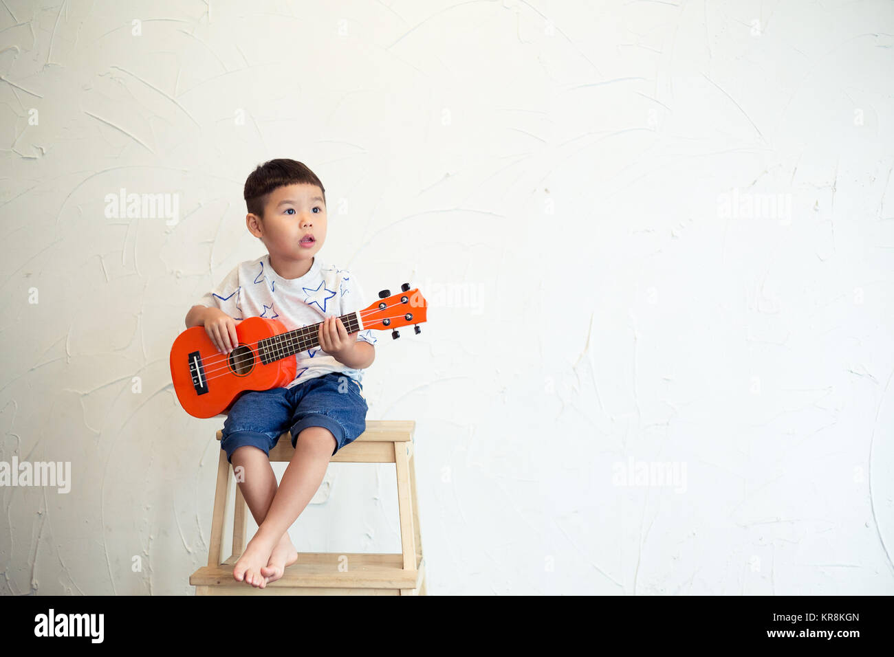 Asian boy playing guitar Stock Photo - Alamy