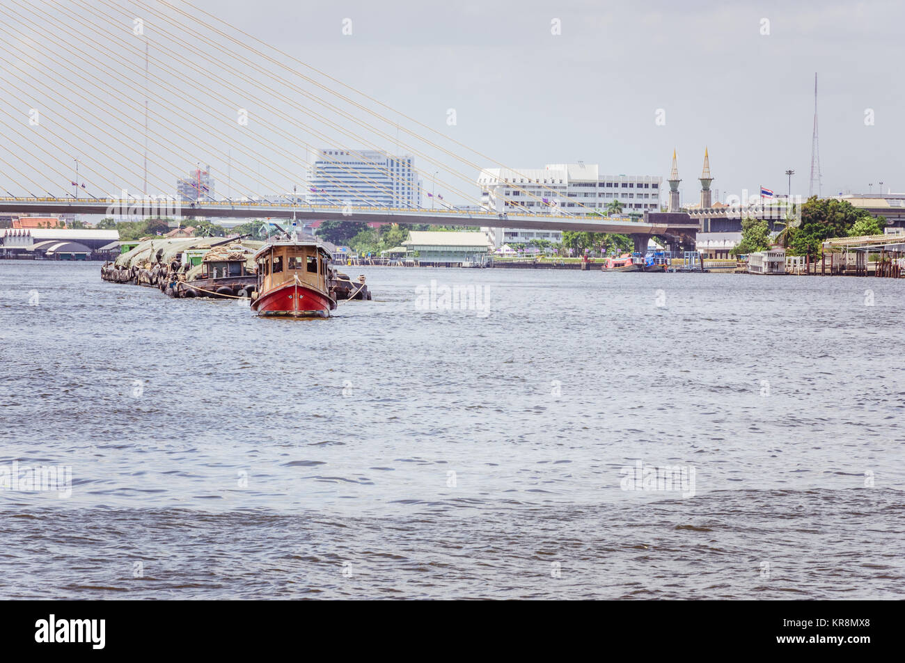 Small boat moving the large one on the river in Thailand Stock Photo ...