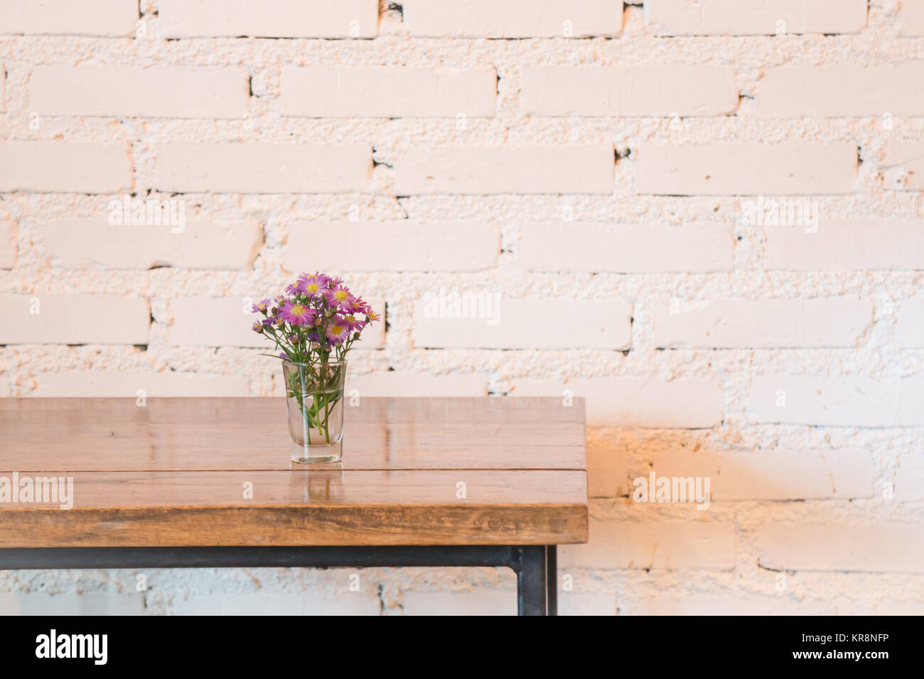 Room interior white brick wall with wooden table Stock Photo - Alamy