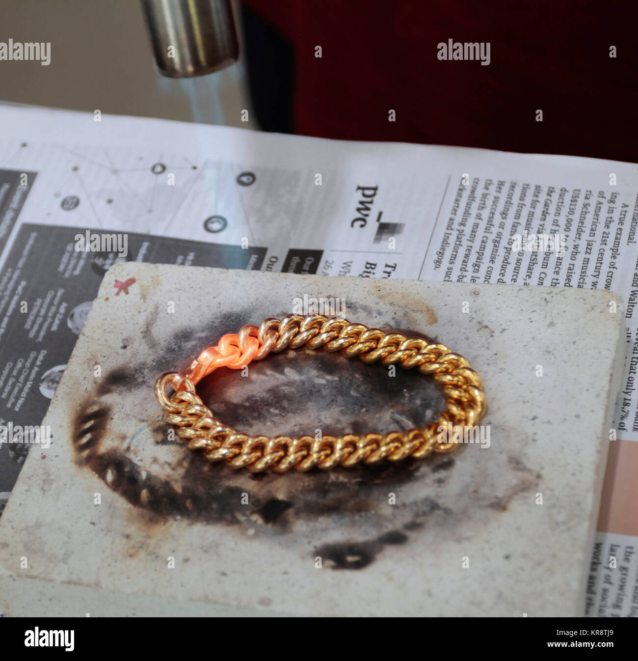 Heating up gold bracelet to red hot Stock Photo - Alamy