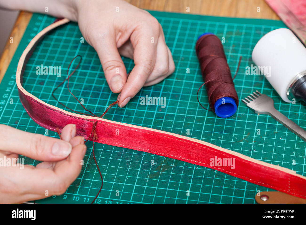 craftsman stitches new leather belt Stock Photo - Alamy