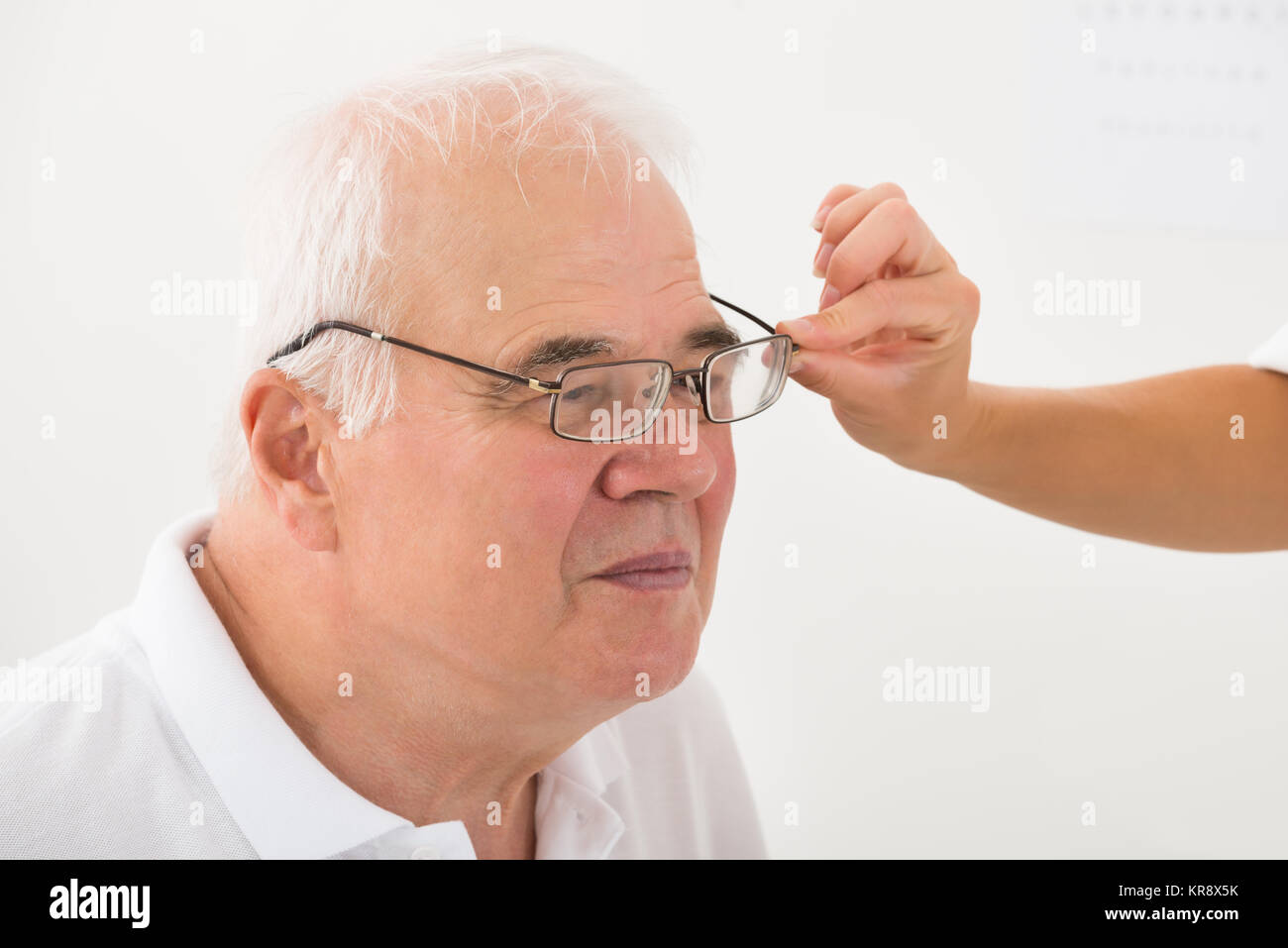 An Optician Helping Male Patient With New Eyeglasses Stock Photo - Alamy