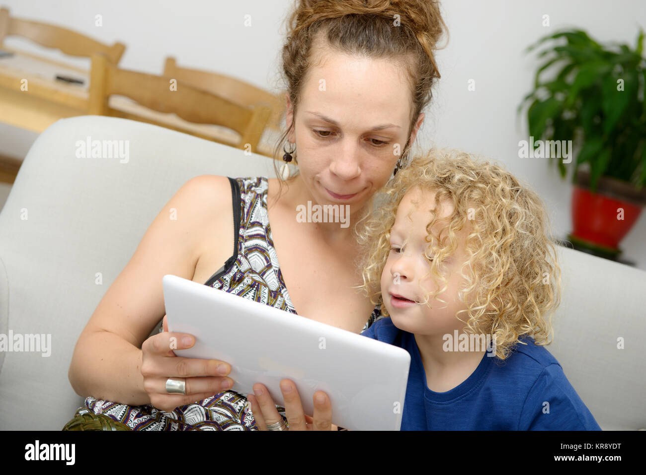 a child and her mom uses a tablet Stock Photo - Alamy