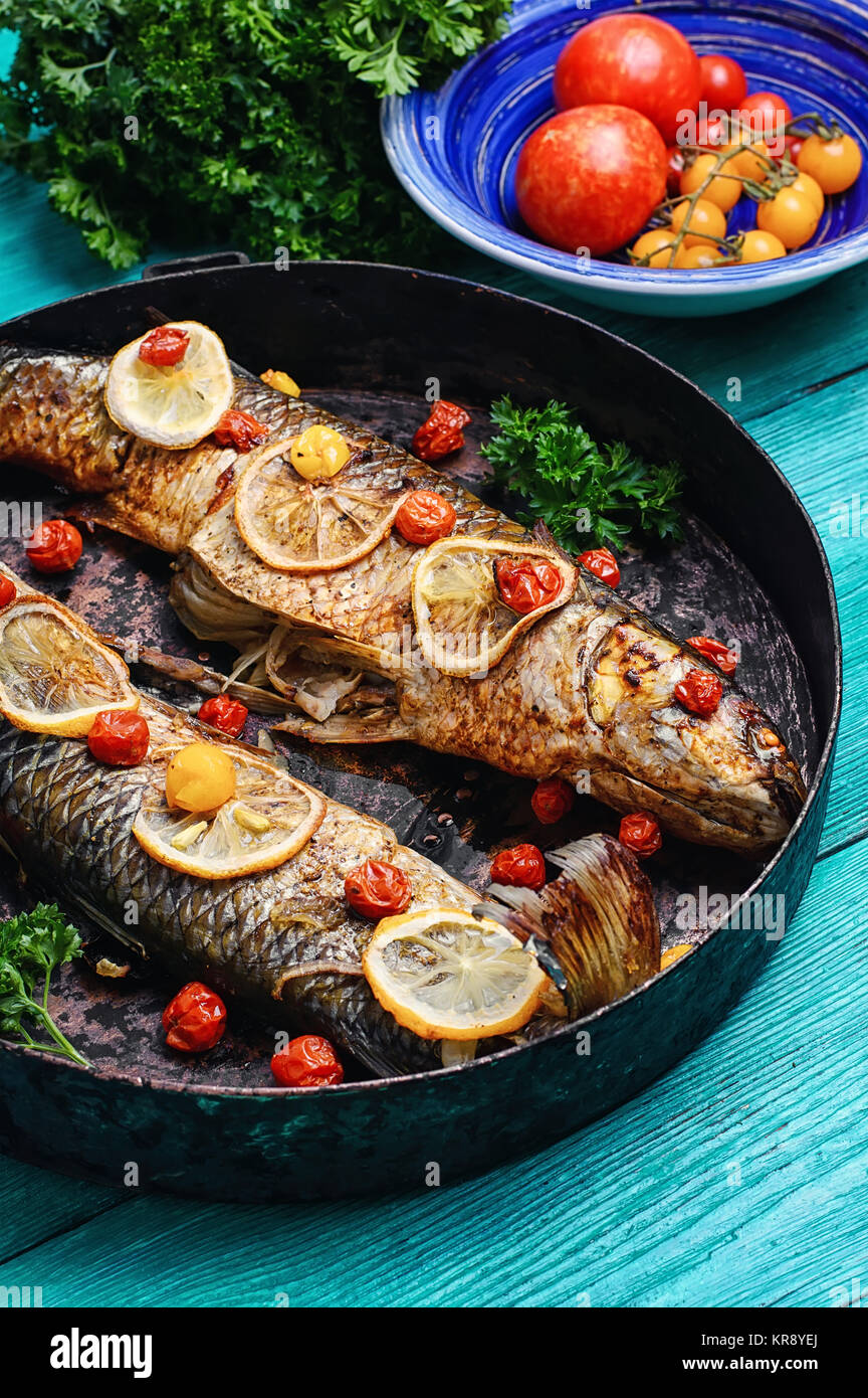 Frying pan with two baked fish in tomatoes,spices and lemon Stock Photo ...