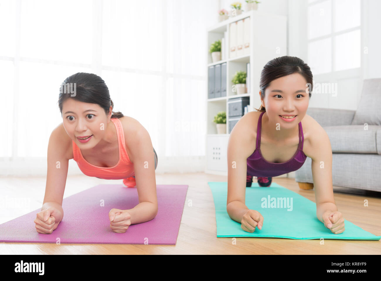beautiful smiling girls making plank posture workout body in living ...