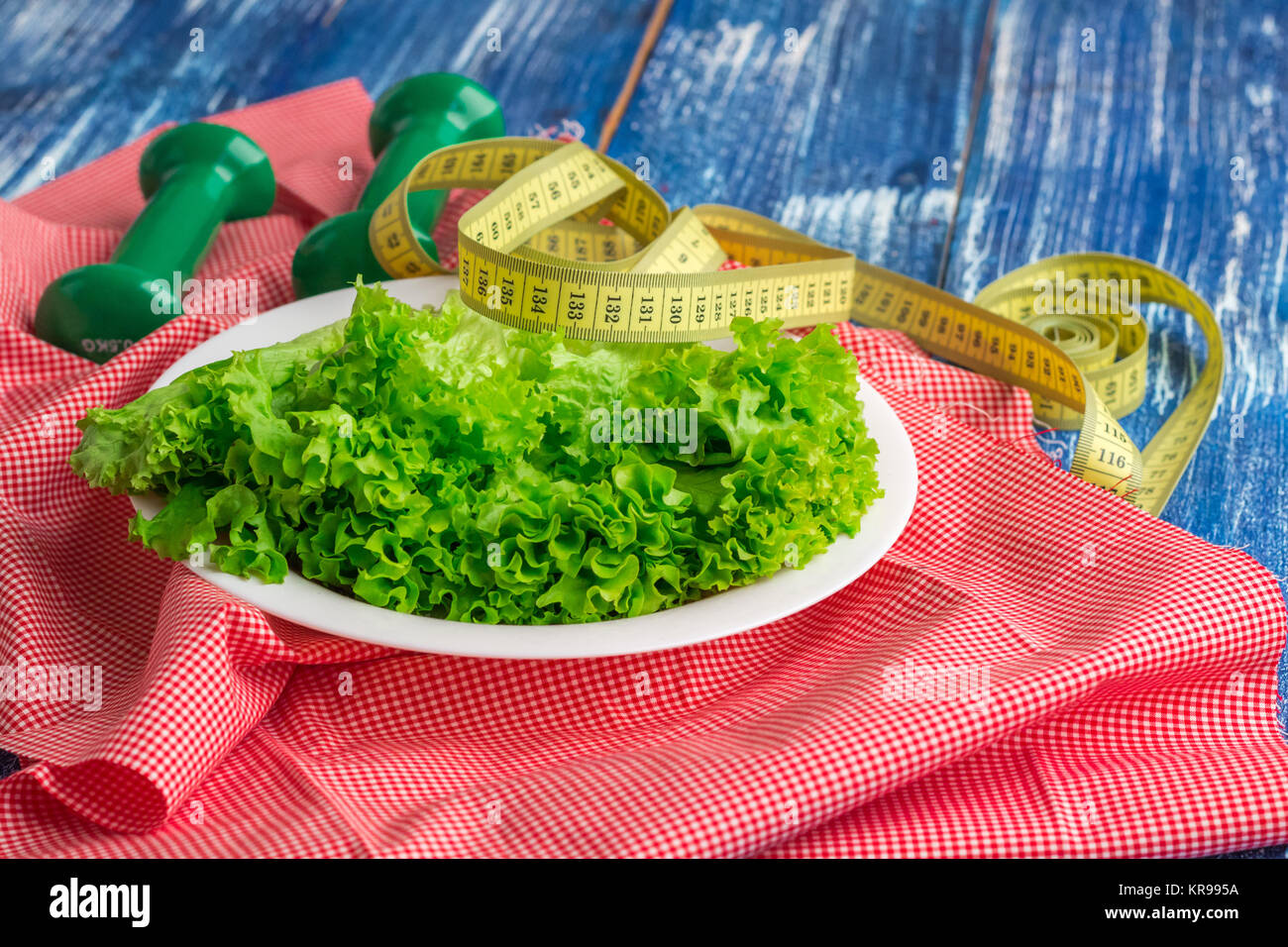Fitness composition of lettuce on plate, weights and ruler Stock Photo ...