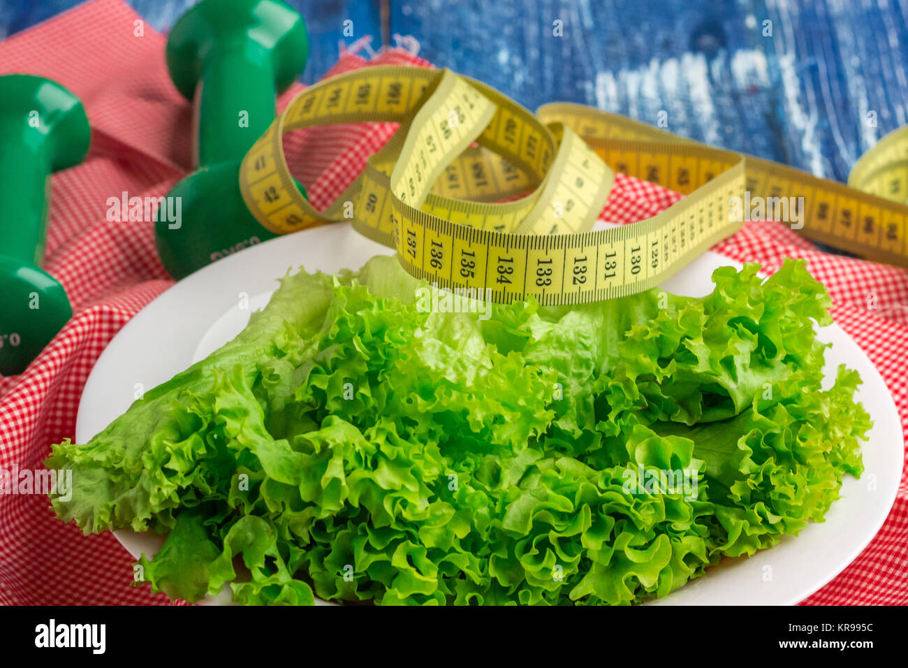 Fitness composition of lettuce, weights and ruler Stock Photo - Alamy