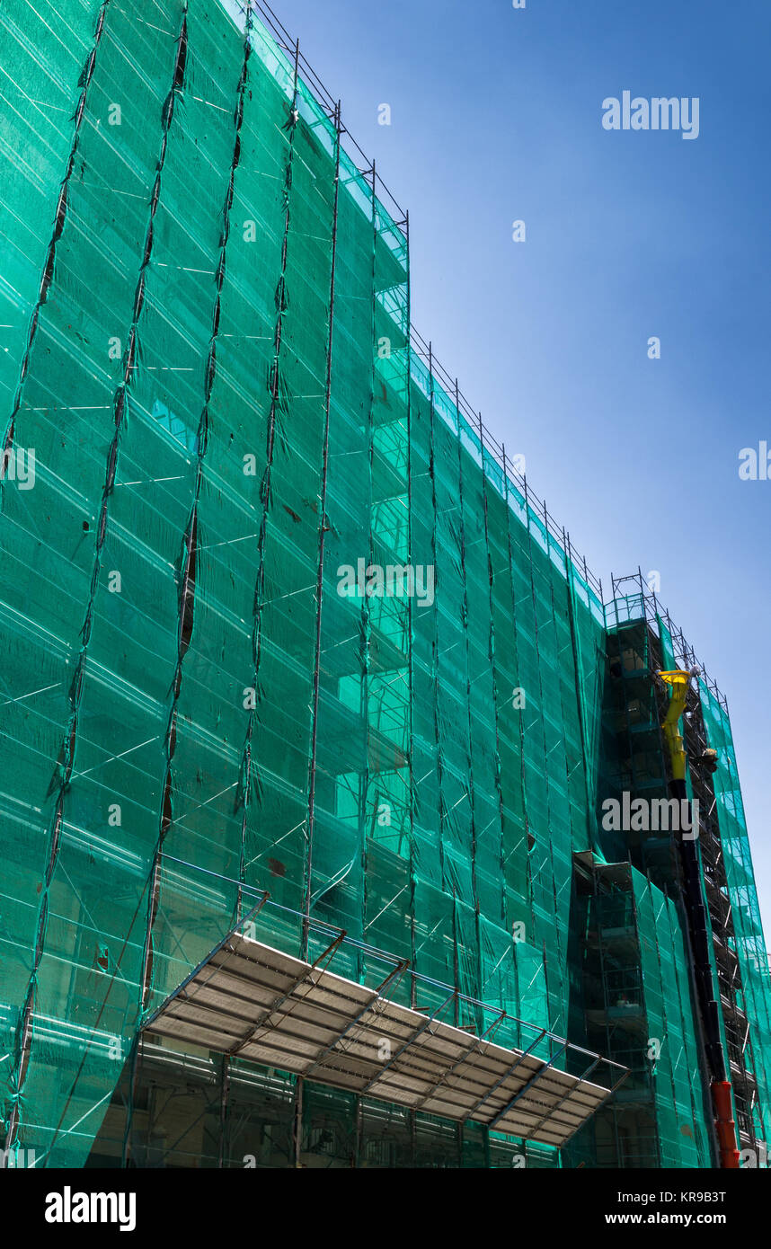 Scaffolding with green network Stock Photo - Alamy