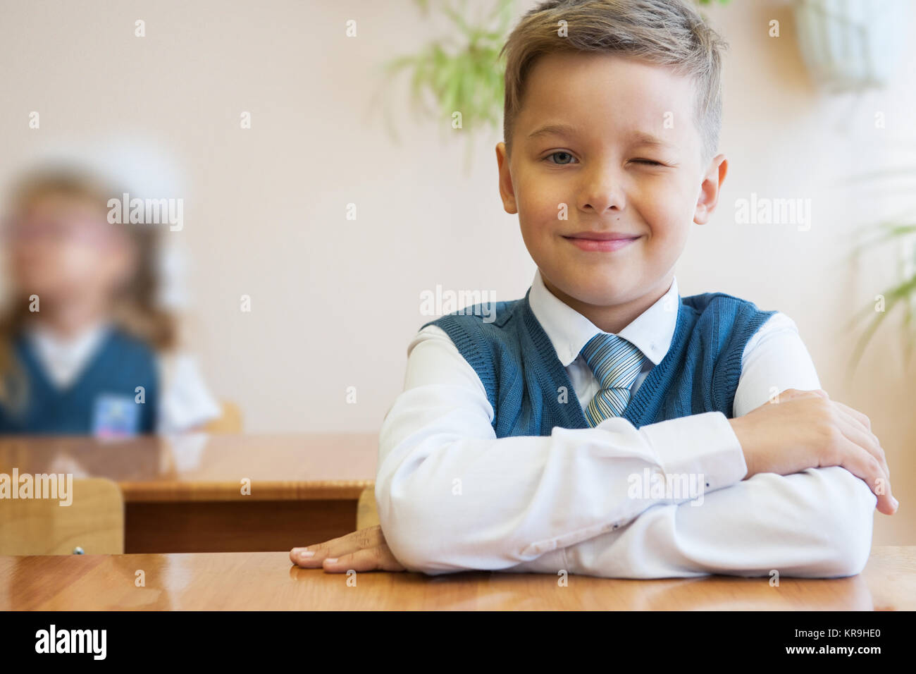 Happy schoolboy sitting at desk Stock Photo - Alamy