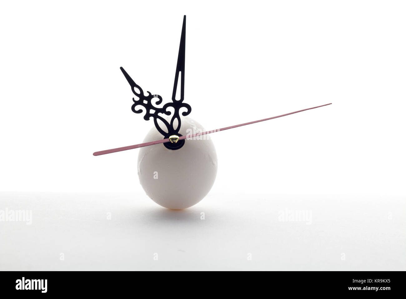 egg and clock hands on white background . Time concept or idea or ...