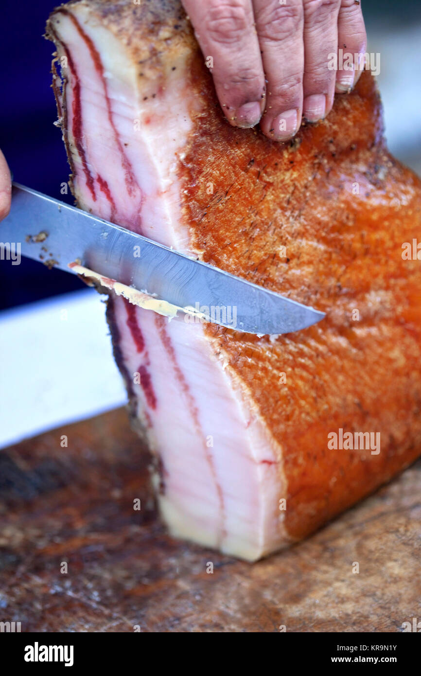 Cutting bacon in a butchery Stock Photo - Alamy