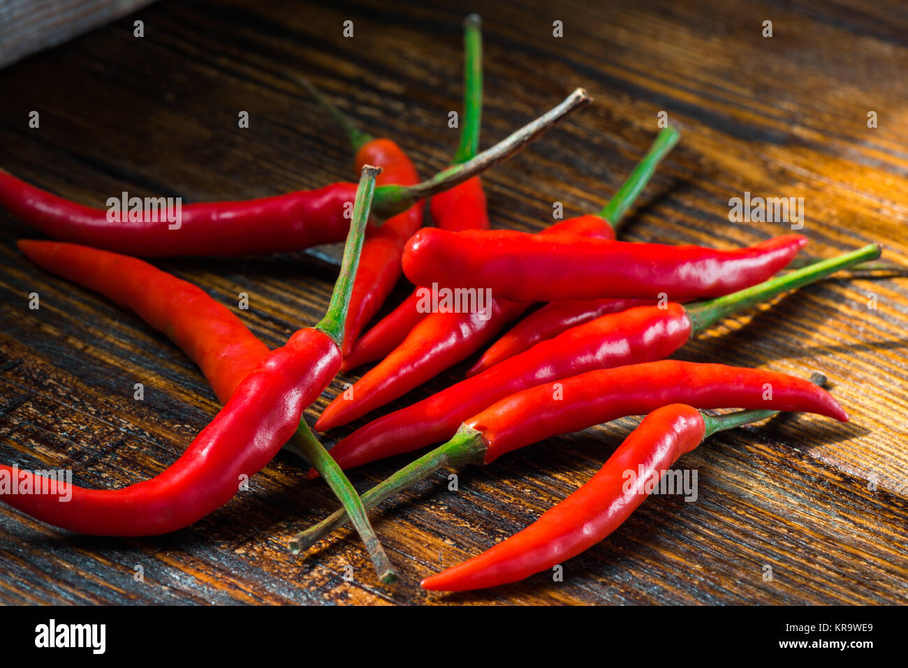 Pile of Mexican mini chili peppers on wooden background Stock Photo - Alamy
