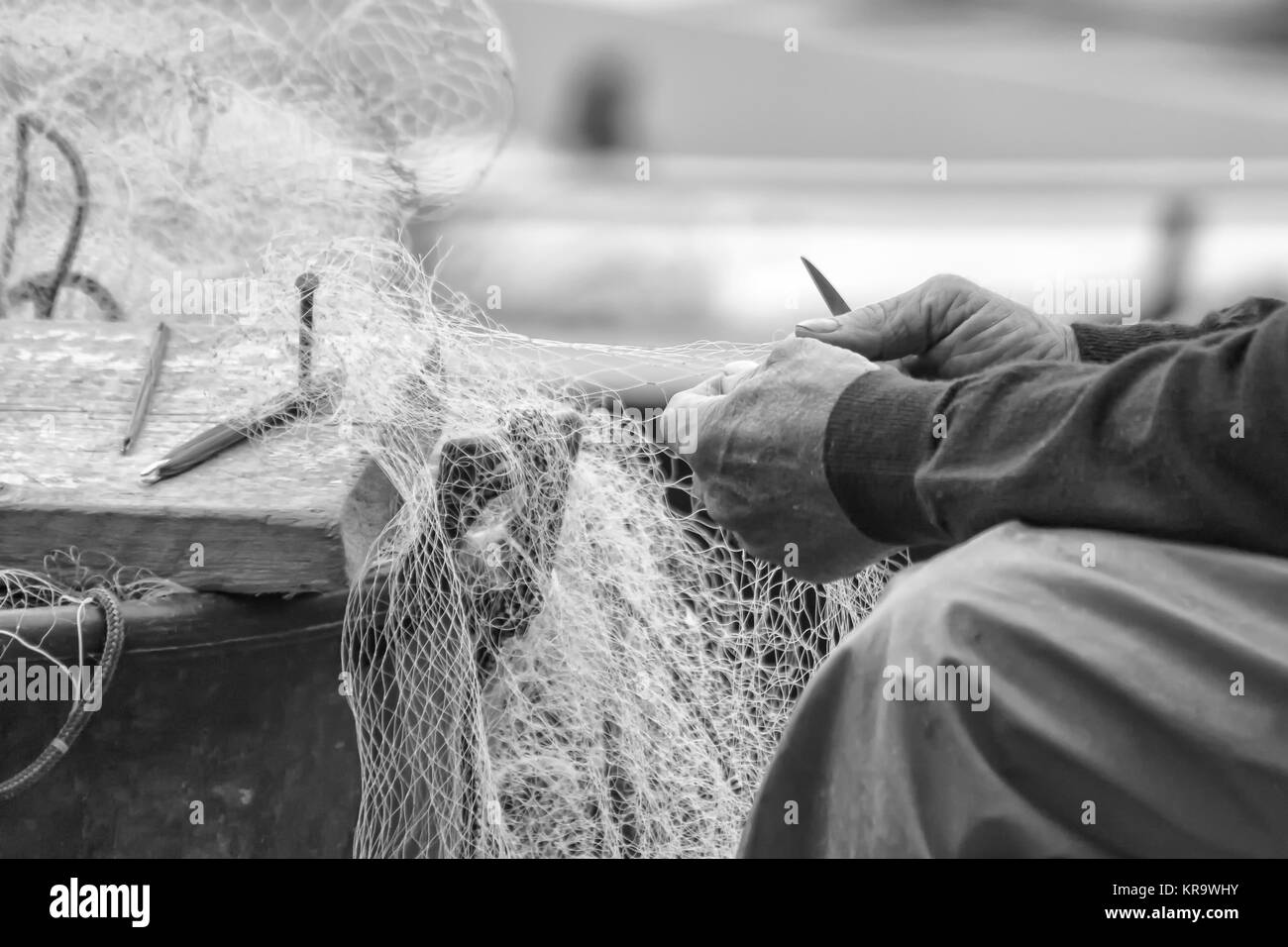 Hands of commercial fisherman mending nets Stock Photo - Alamy