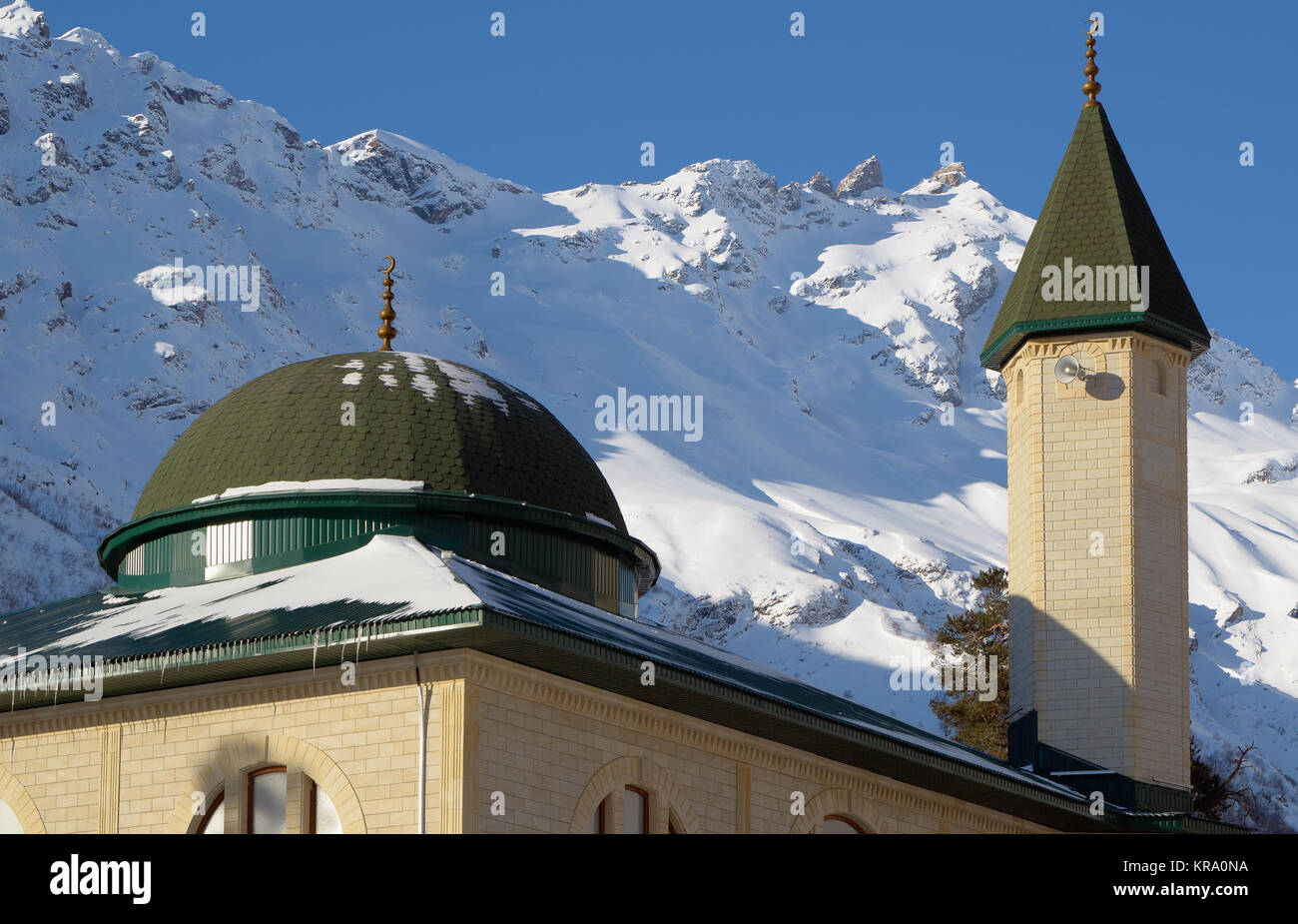 Minaret and roof of the mosque on the background of snow-capped ...