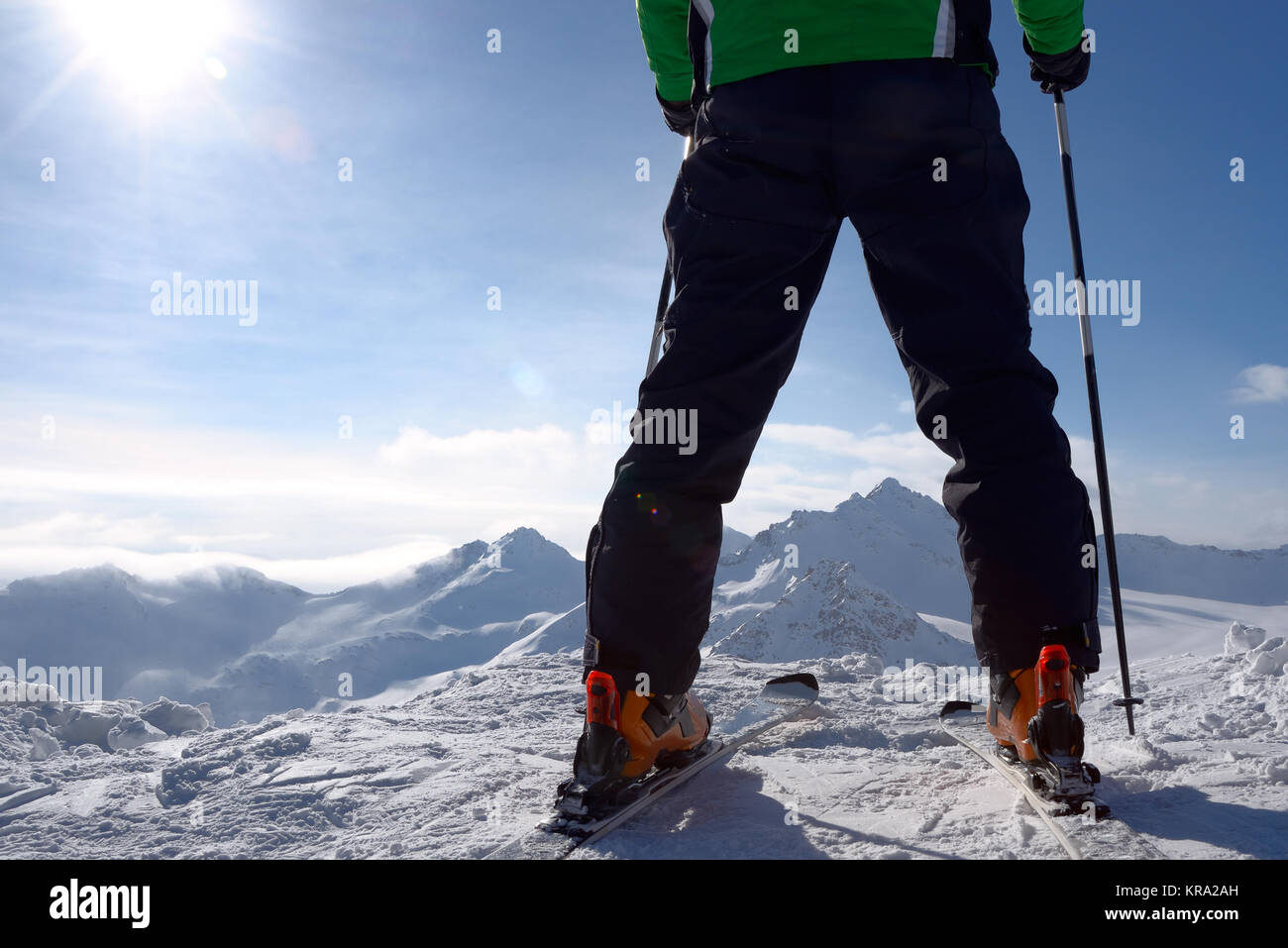 Close up of ski legs and ski pole against mountain background, low ...
