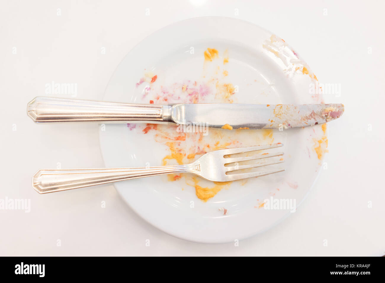 Empty white plate with crumbs and cream Stock Photo - Alamy