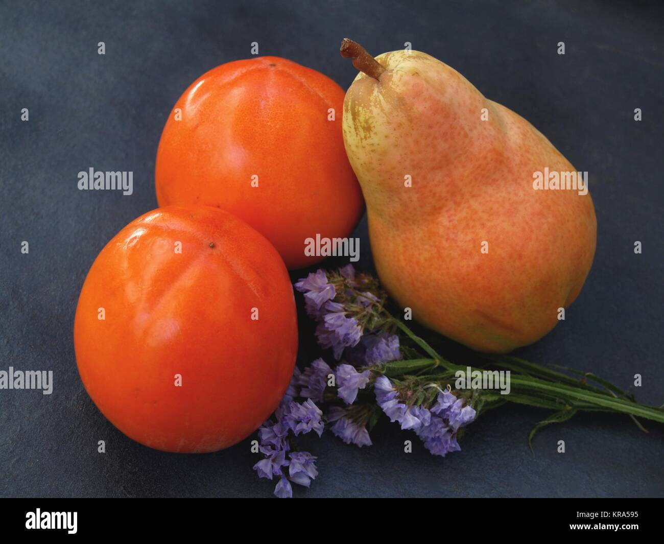 persimmons, pear and dry flowers Stock Photo - Alamy