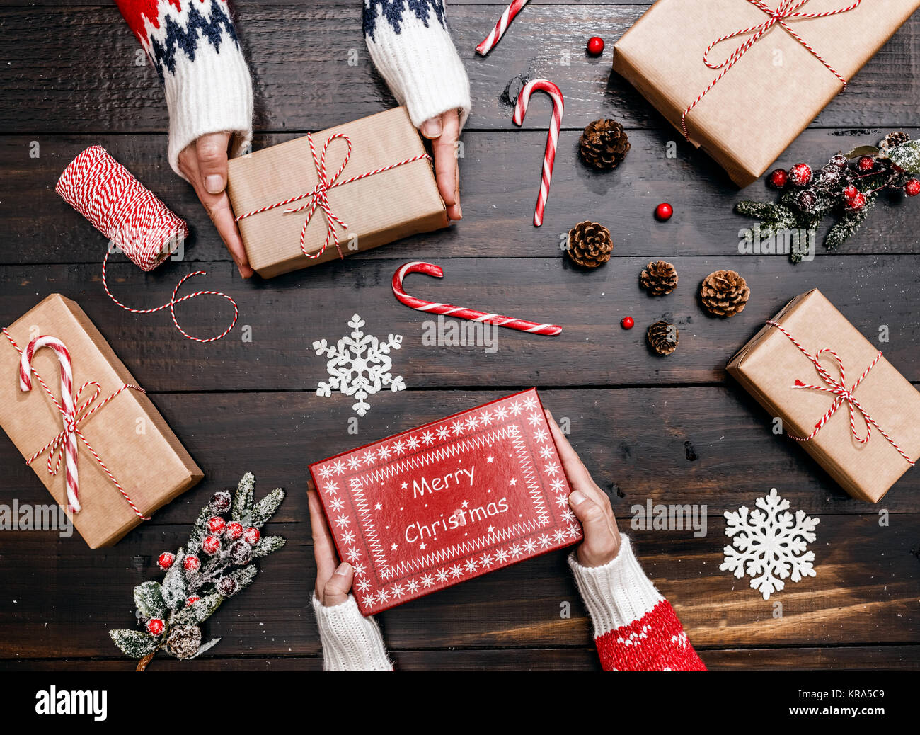 Family Hands showing Christmas present. Wooden background with ...