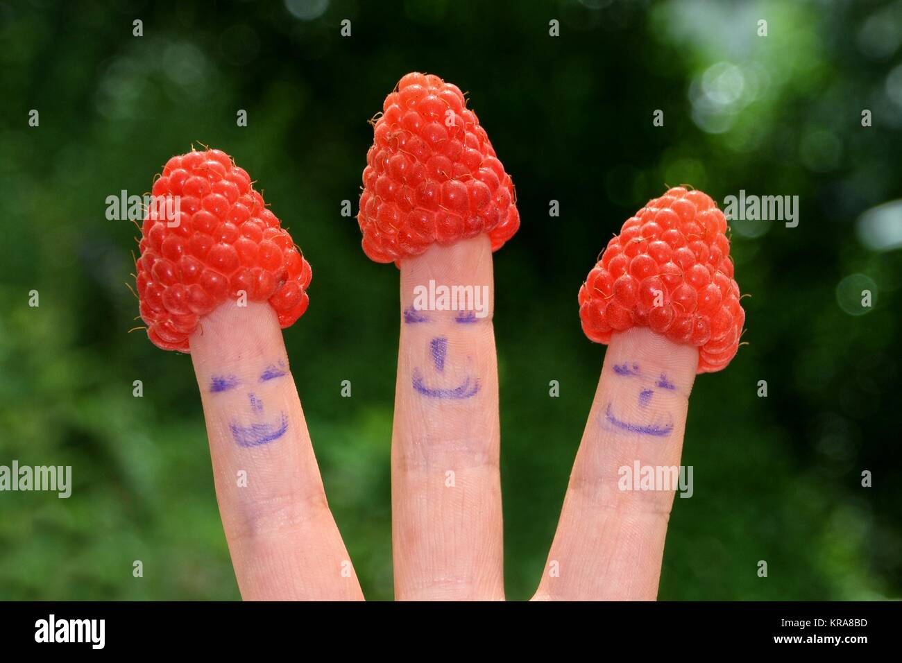 three fingers with patch raspberries and laughing faces Stock Photo - Alamy