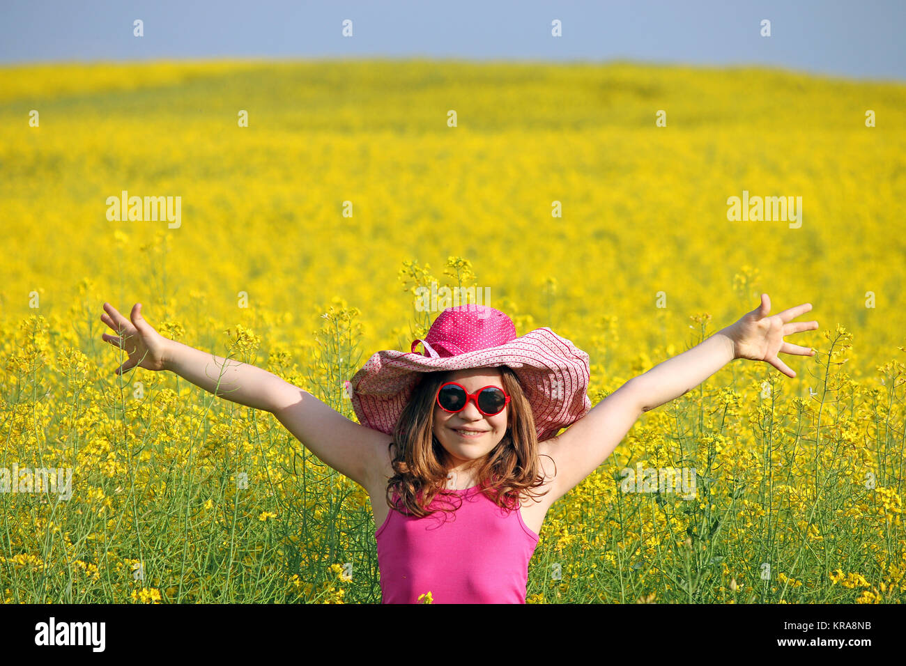 Happy little girl with hands up on field spring season Stock Photo - Alamy