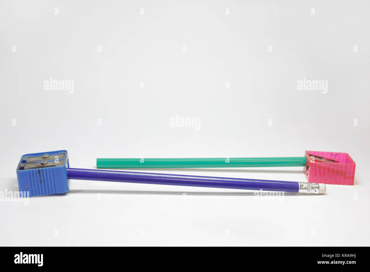 pencil sharpeners and two pencils: green and blue with eraser on the ...